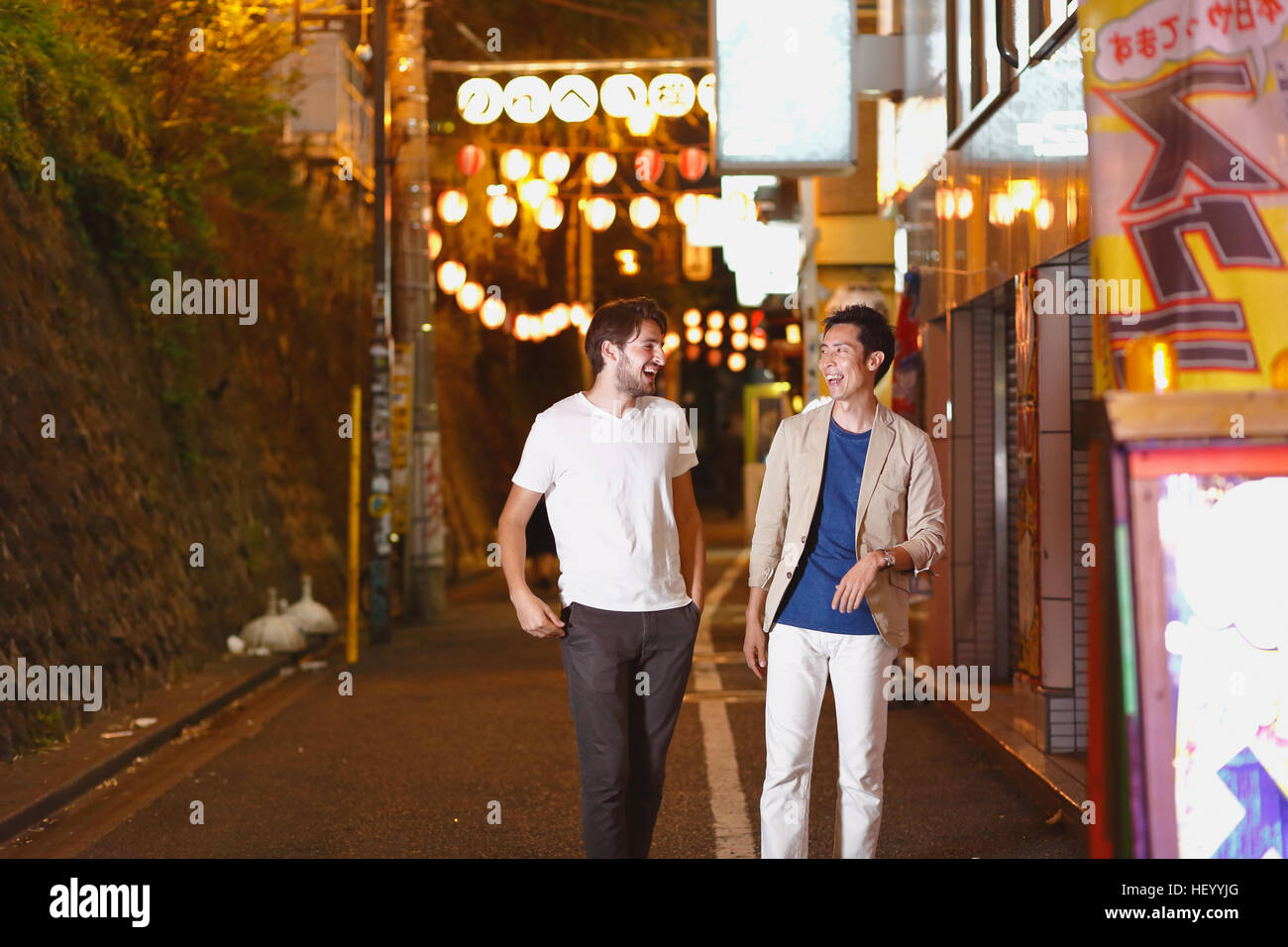 Caucasian man enjoying nightlife in Tokyo with Japanese friend, Japan ...