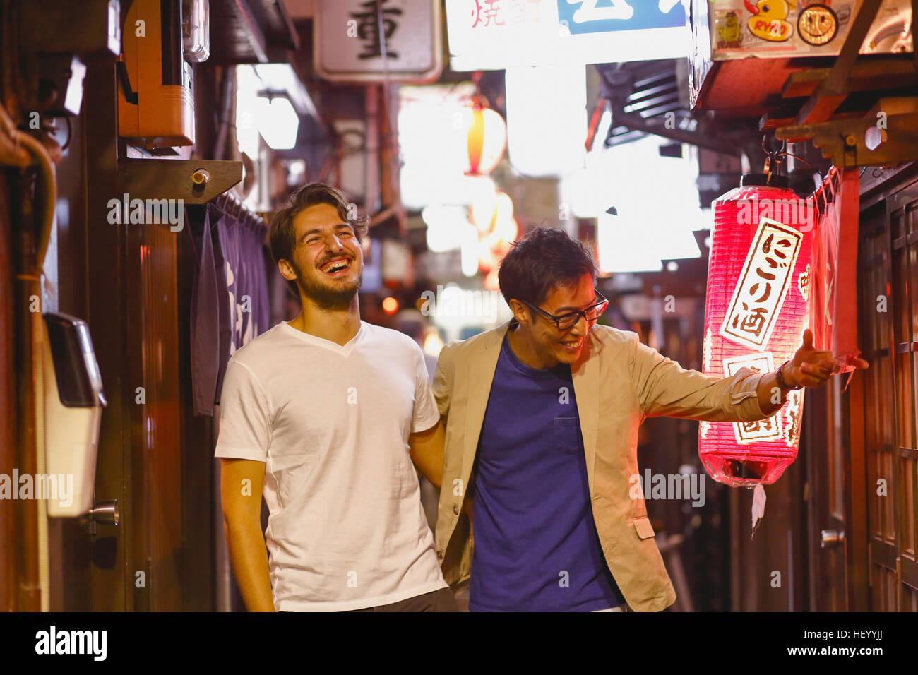Caucasian man enjoying nightlife in Tokyo with Japanese friend, Japan ...