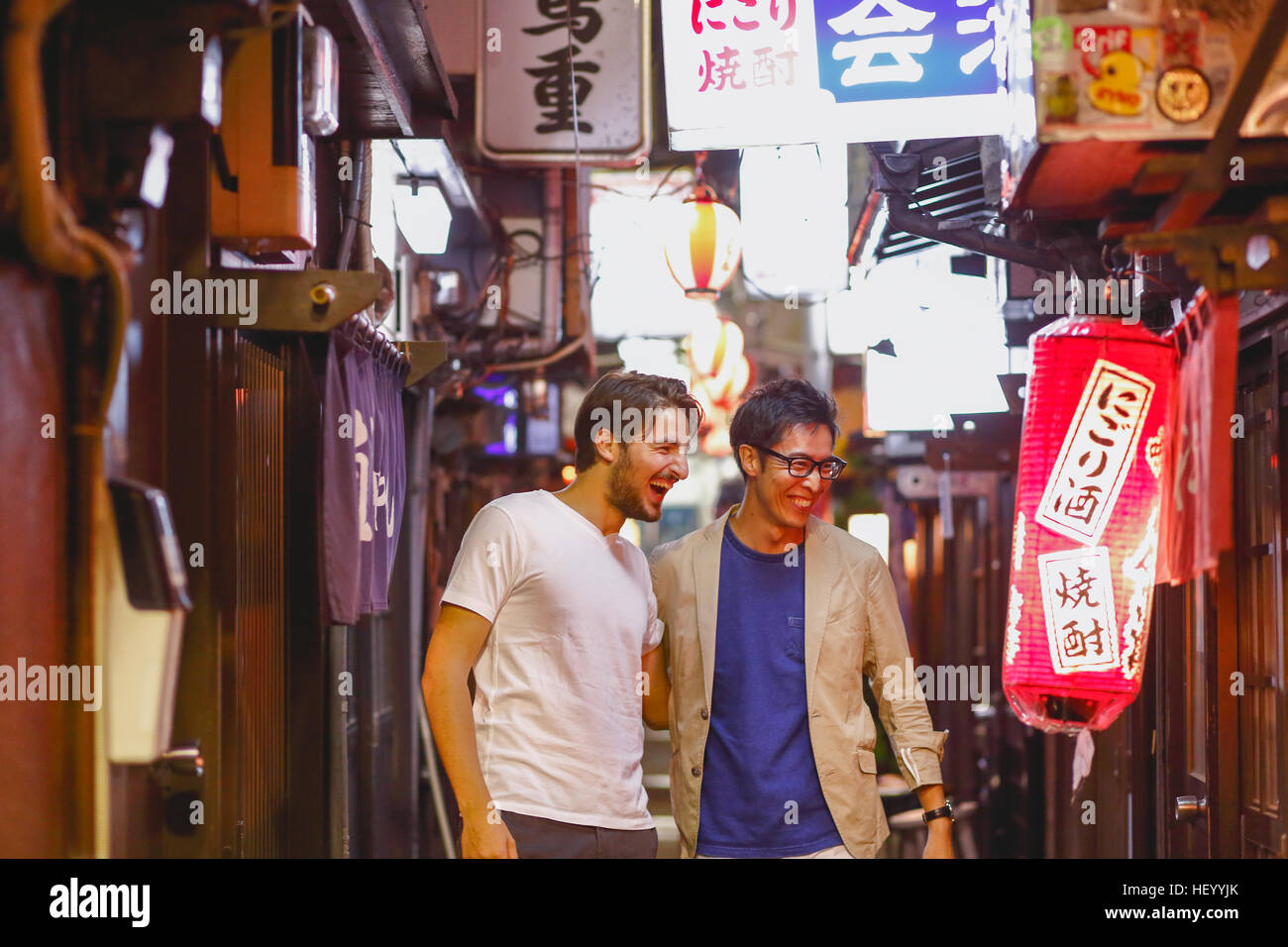 Caucasian man enjoying nightlife in Tokyo with Japanese friend, Japan ...