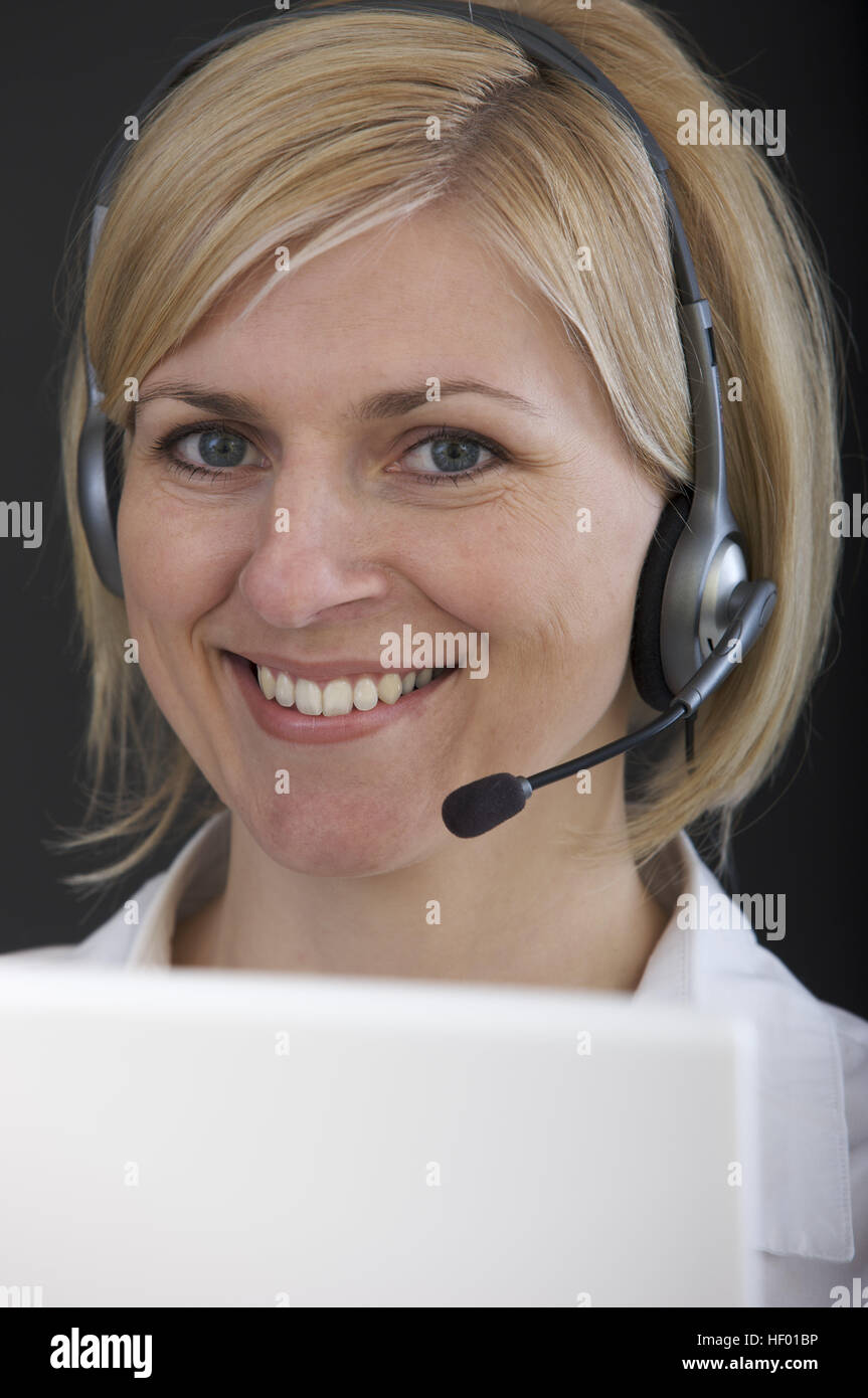 Blonde woman wearing a headset Stock Photo - Alamy