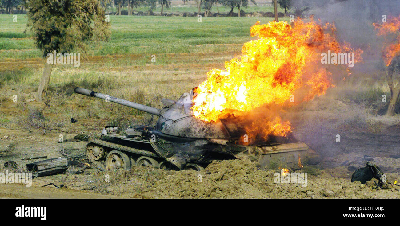 A destroyed Iraqi T-55 Medium Battle Tank (MBT) burns near the An Nu ...