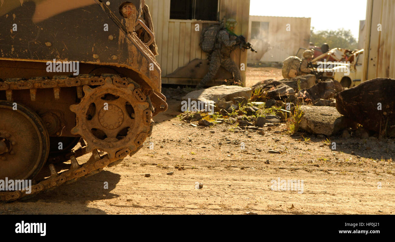 An Australian tank roles past a squad in the Australian Defence Force ...