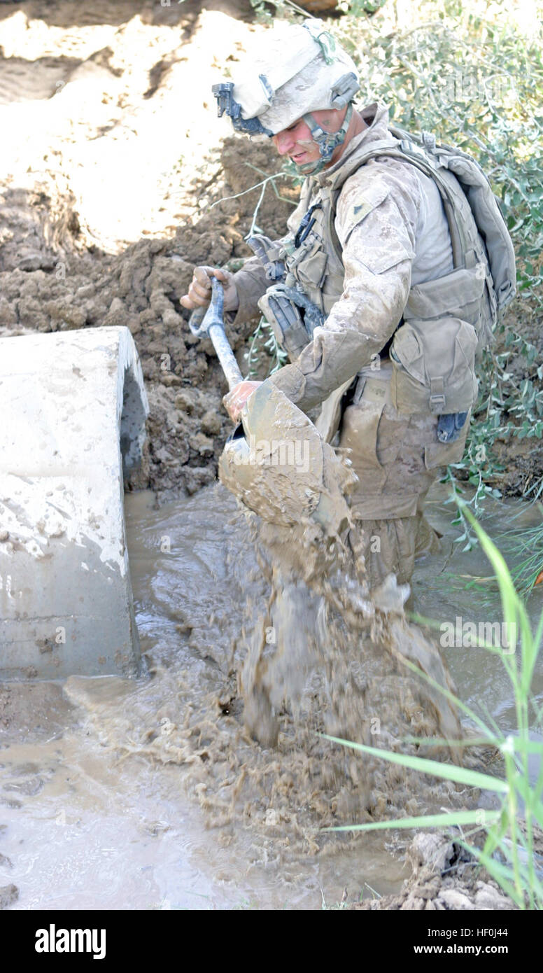 A Marine with 2nd Battalion, 9th Marines, shovels out dirt from a newly ...