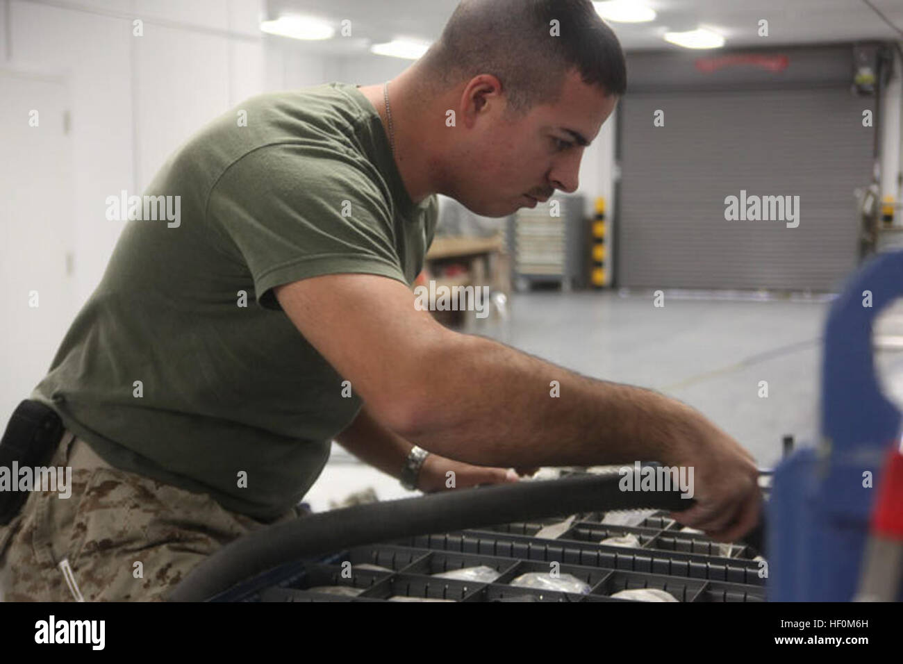 Petty Officer 2nd Class Christopher Hoyer cleans out a parts cabinet at ...
