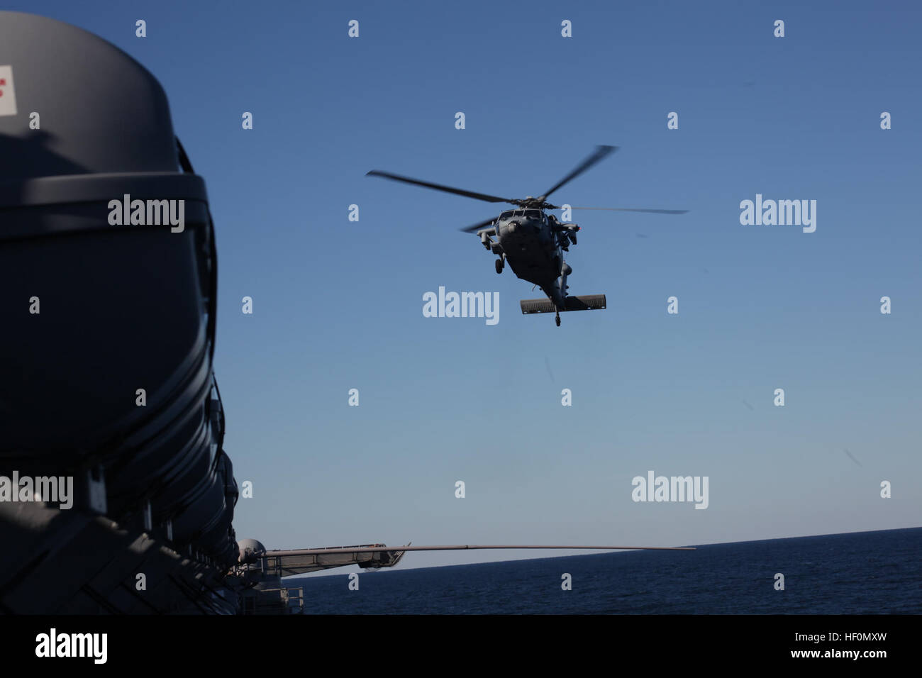 A Navy SH-60 Seahawk helicopter practices lifting off and landing from ...