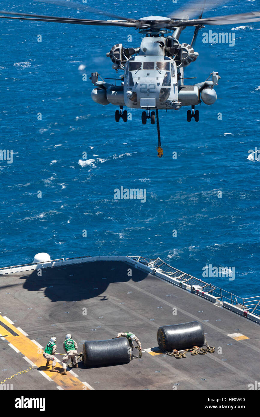 A CH-53E Super Stallion hovers above the flight deck of the USS Peleliu ...