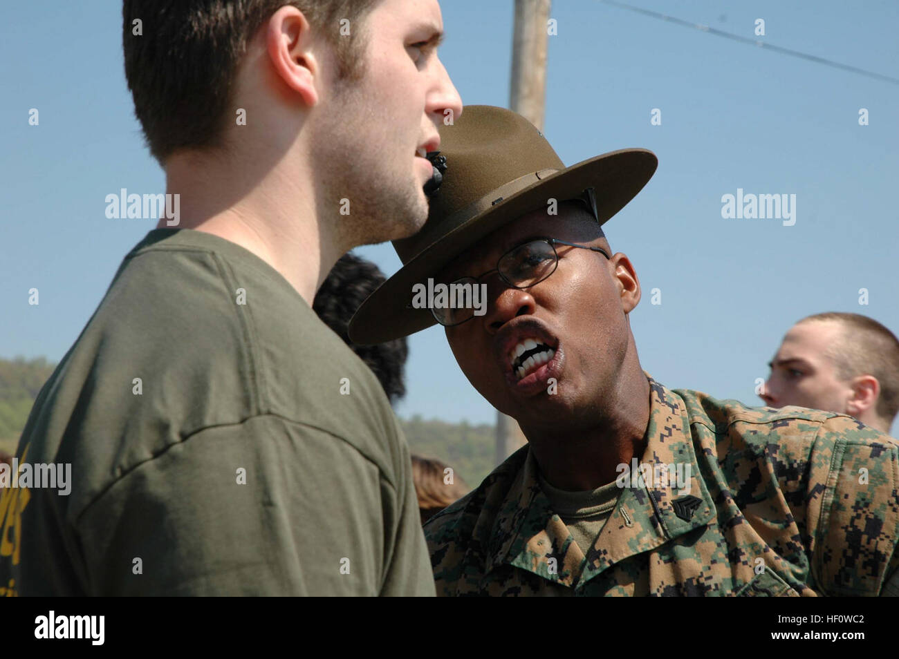 A Marine Corps drill instructor supervises and trains a recruit during ...