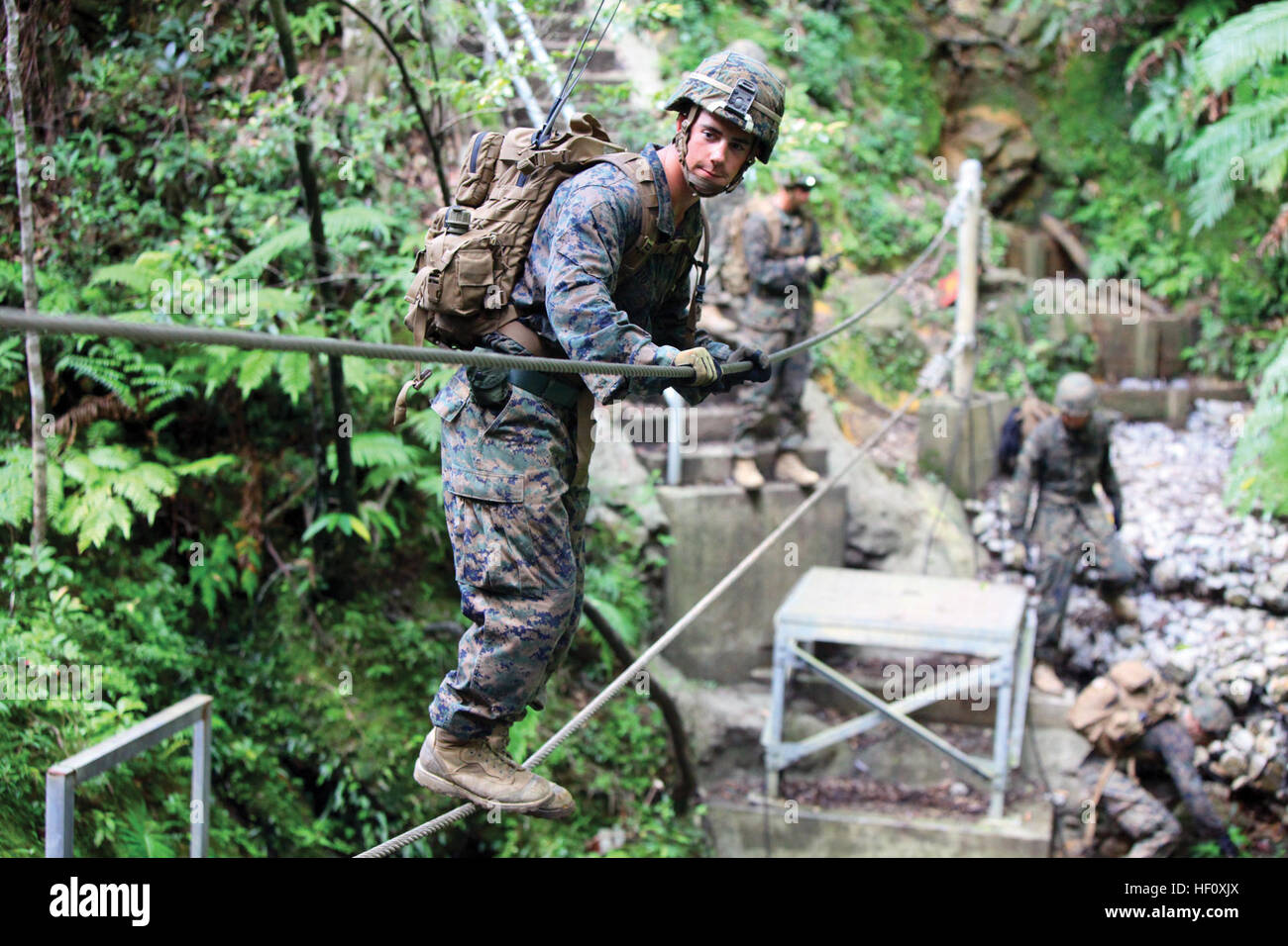Lance Cpl. Matthew J. Vito traverses a rope bridge to cross a ravine ...
