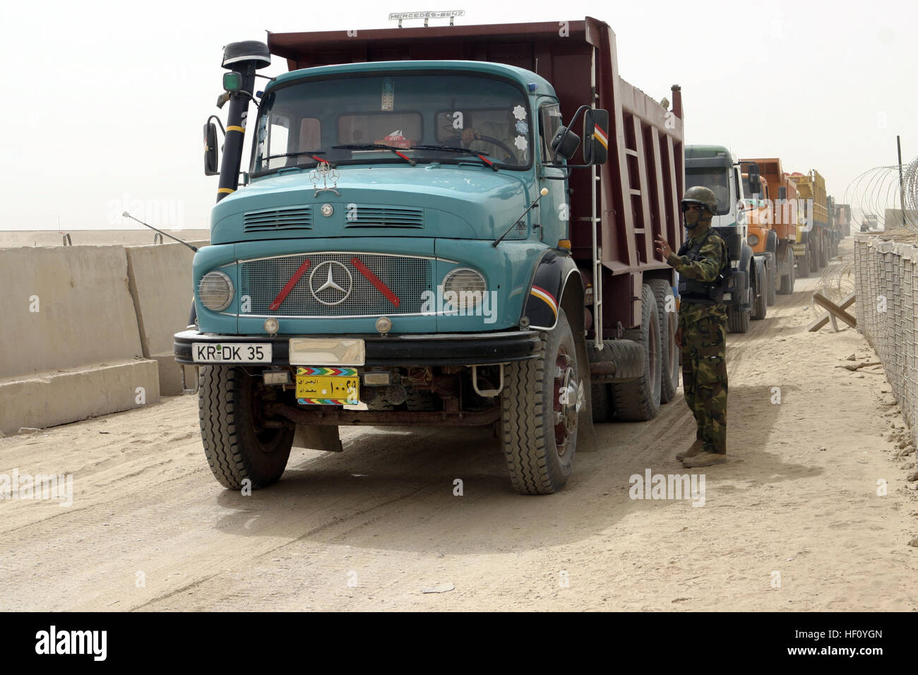 FALLUJAH, Iraq – An Iraqi policeman directs heavy truck traffic aboard ...
