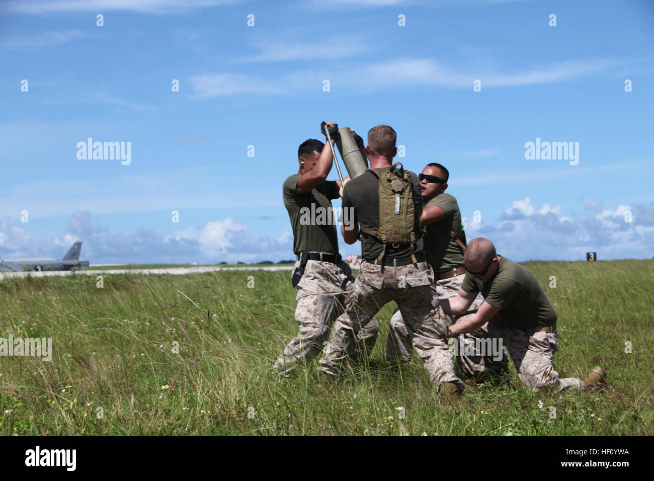 Three Marines and a Navy corpsman work together to anchor a guy wire ...