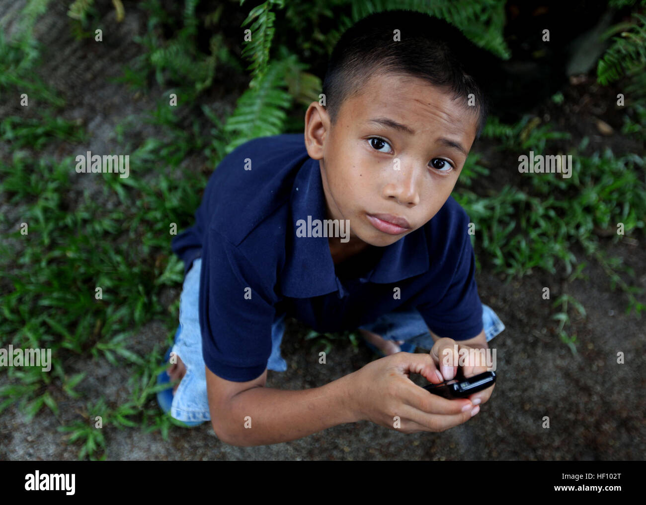 A seven-year old Philippine boy plays games on a U.S. Marine's cell ...