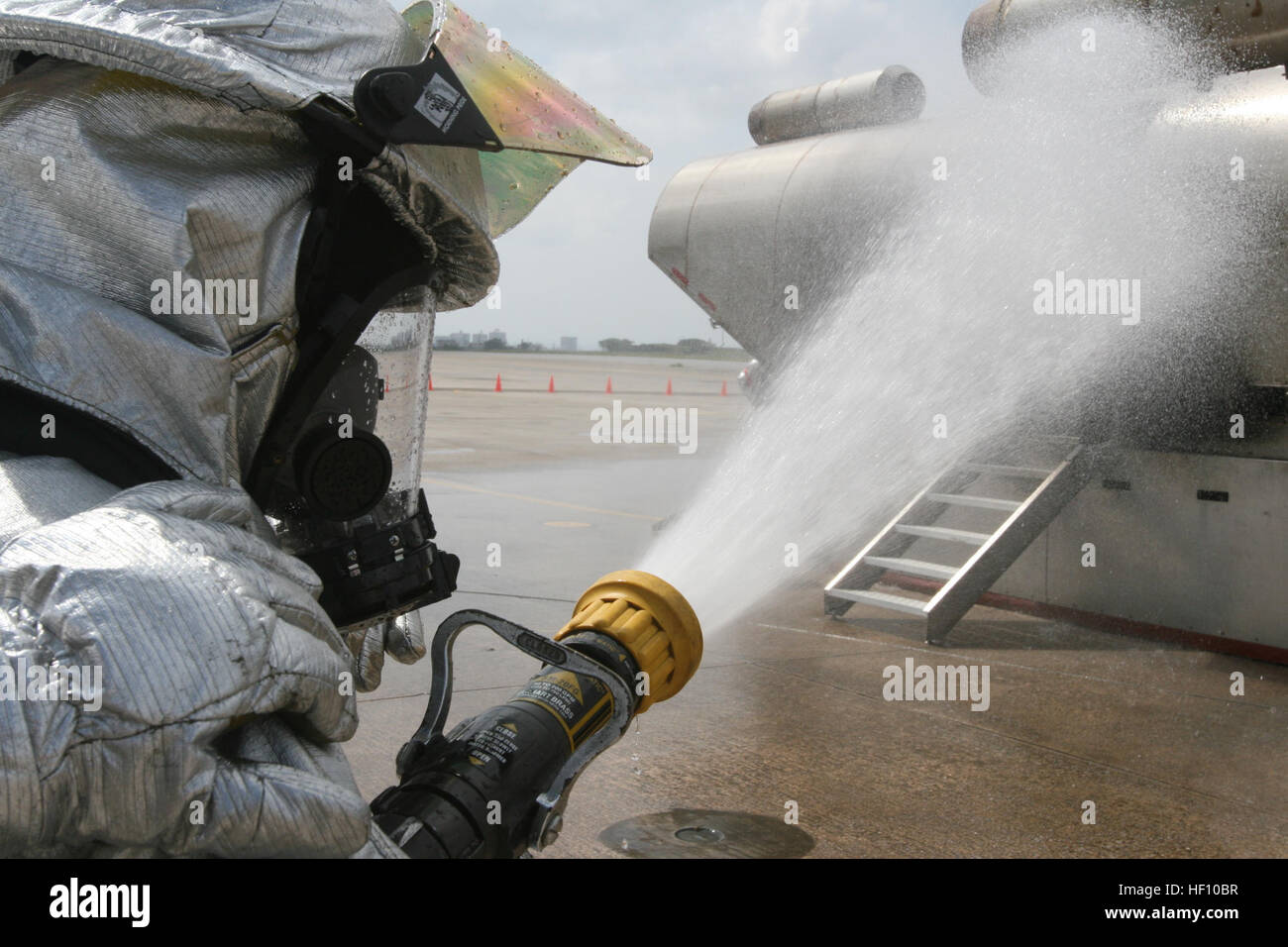 An aircraft rescue and firefighting Marine demonstrates proper fire ...