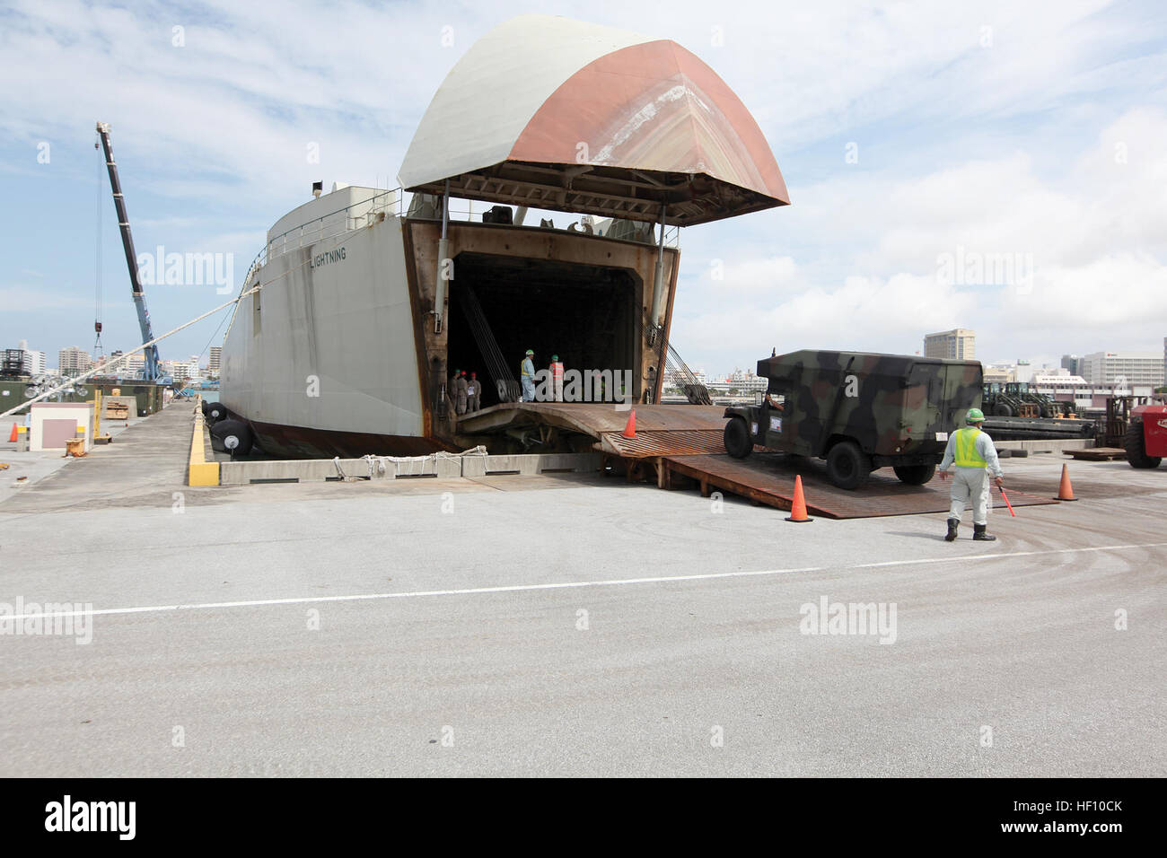 A Marine drives a humvee aboard the integrated tug and barge vessel ...