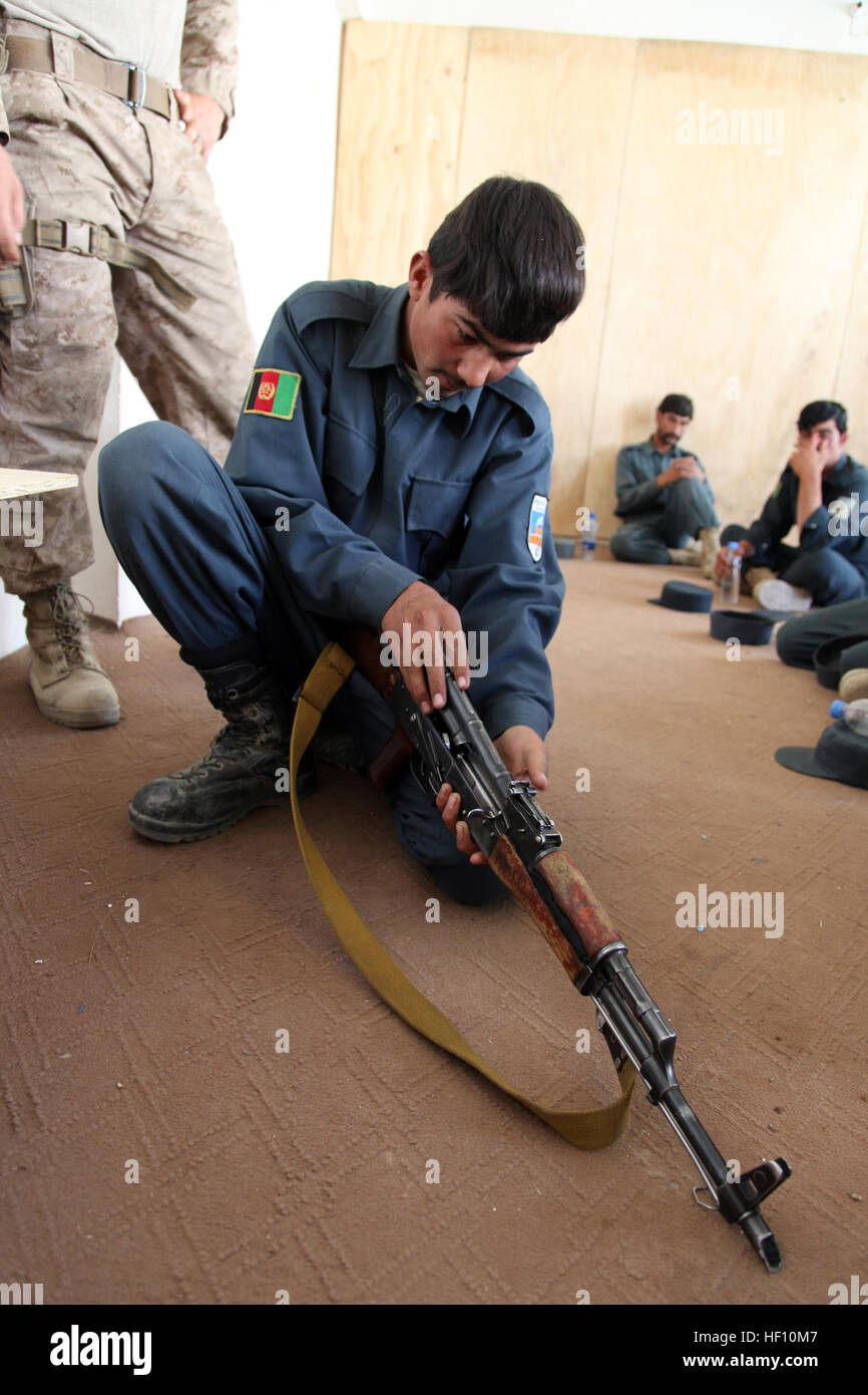 An Afghan Local Police (ALP) trainee removes the bolt from an AK-47 ...