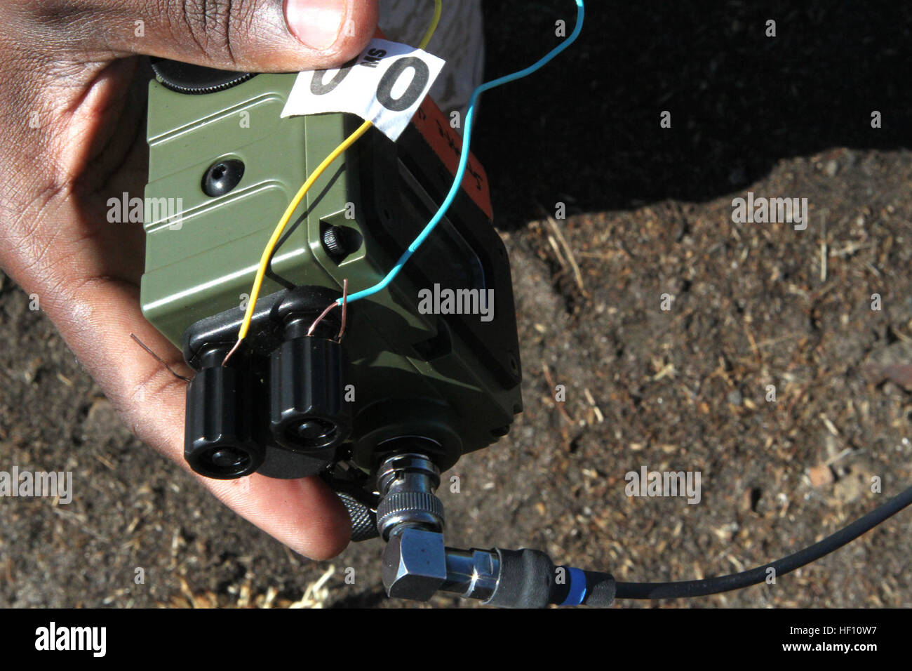 An explosive ordnance disposal technician attaches wires to a detonator ...