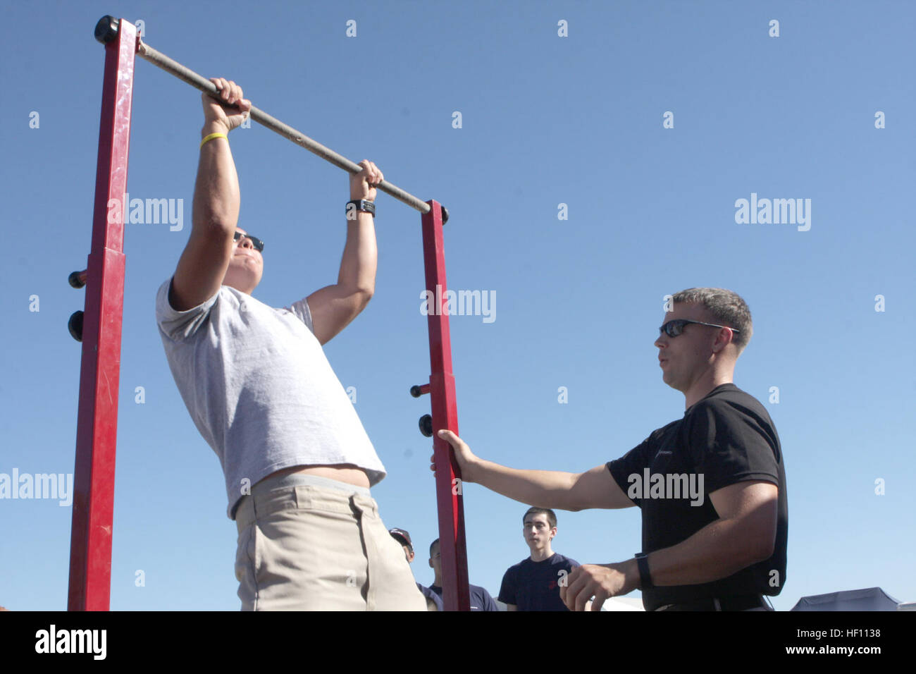 A Marine counts how many pull ups a spectator completes at the Marine ...
