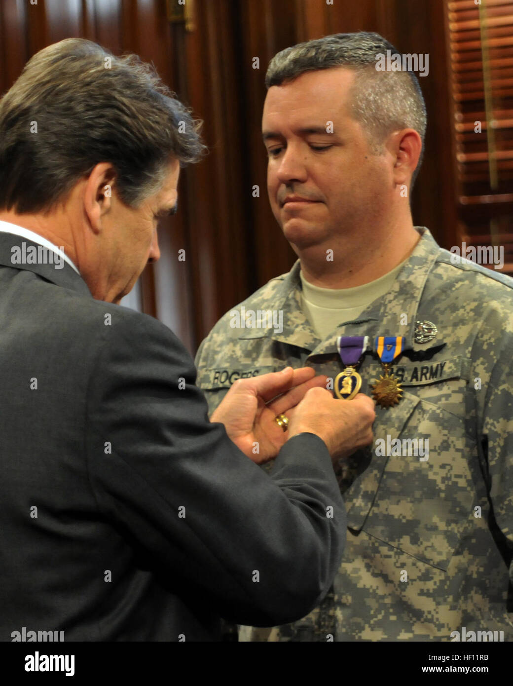Texas Gov. Rick Perry finishes placing the Purple Heart onto the ...