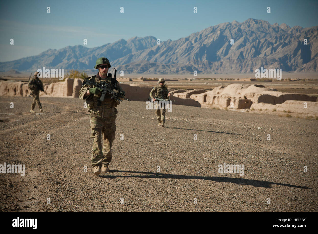 Coalition force members patrol through a village during a presence ...