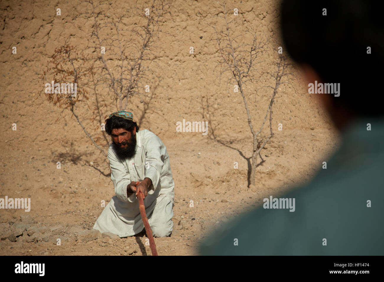 An Afghan National Policman (right) watches an Afghan Local Policeman ...