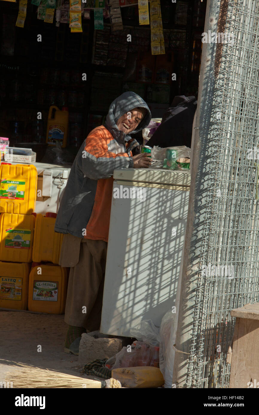 An Afghan boy helps his father and brother mind the families store ...