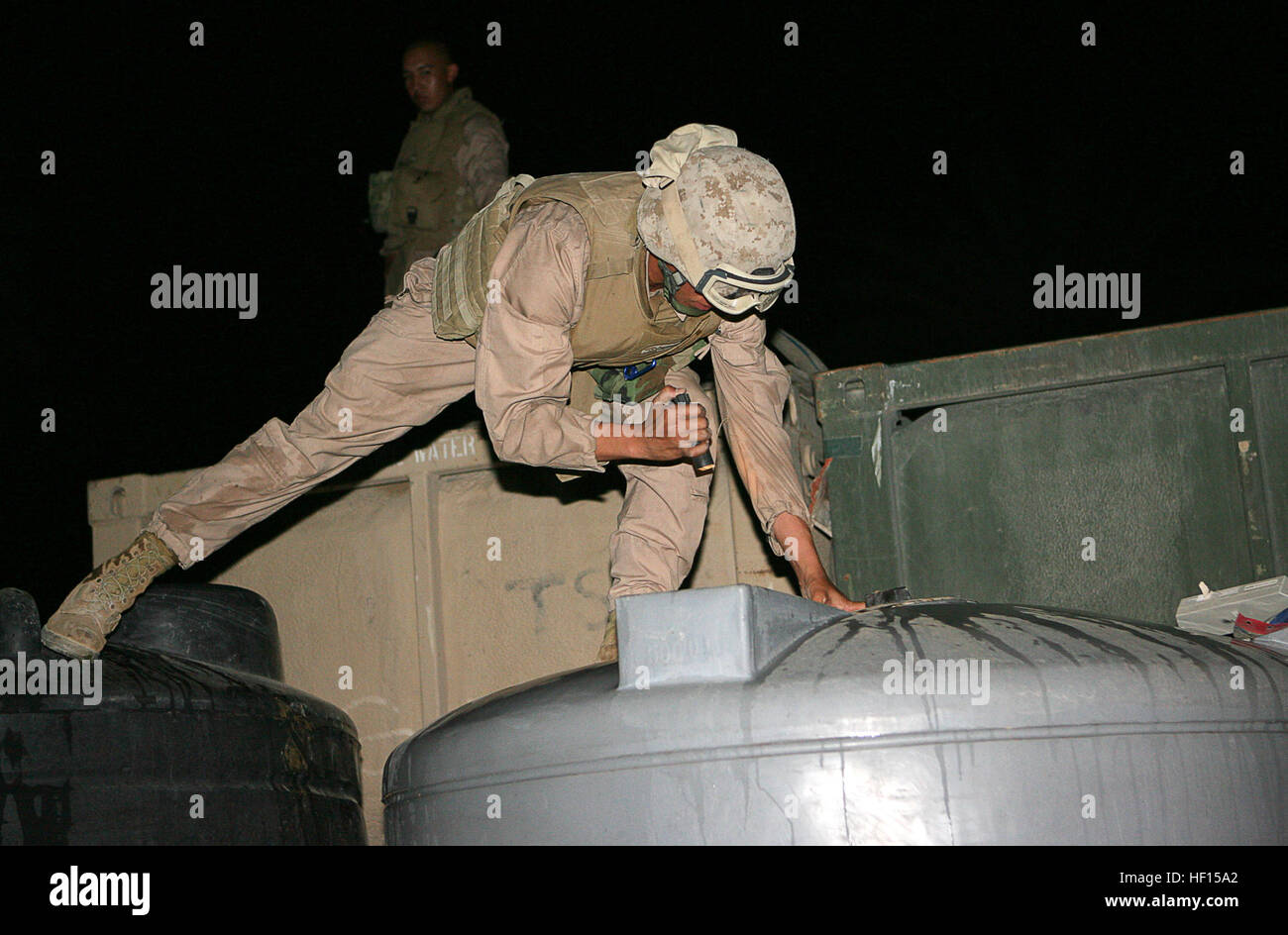 Taking a peak at the levels of a water container, Lance Cpl. Paul W ...