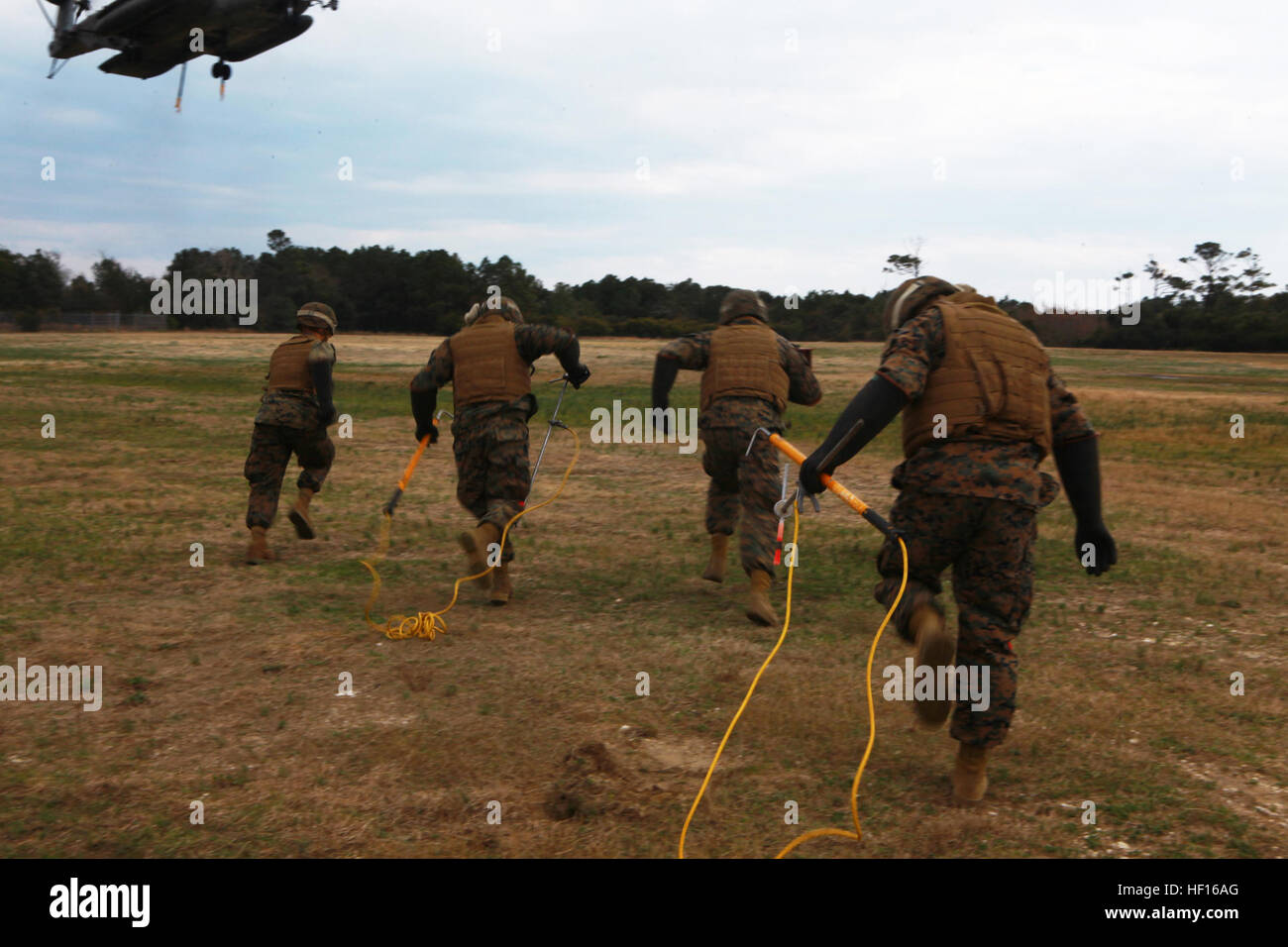 A crew of landing support specialists race towards a CH-53E Super ...