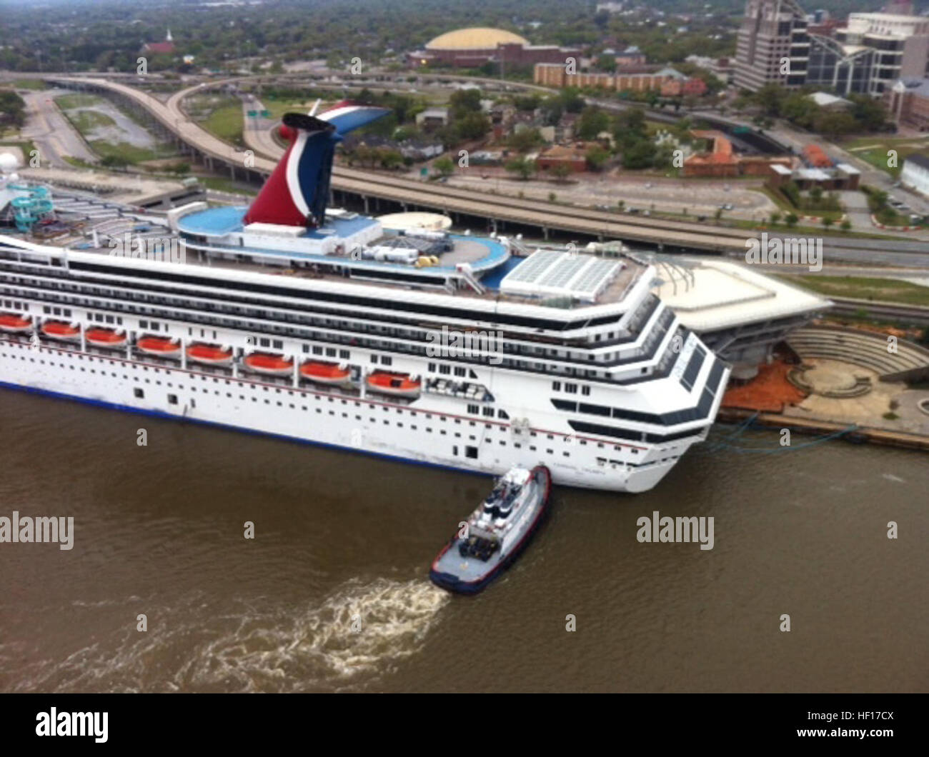 A tug vessel pushes the Carnival Triumph to moor at the Signal ...