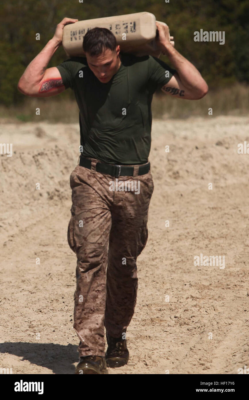 A Marine with 10th Marine Regiment carries a water jug to help his team ...