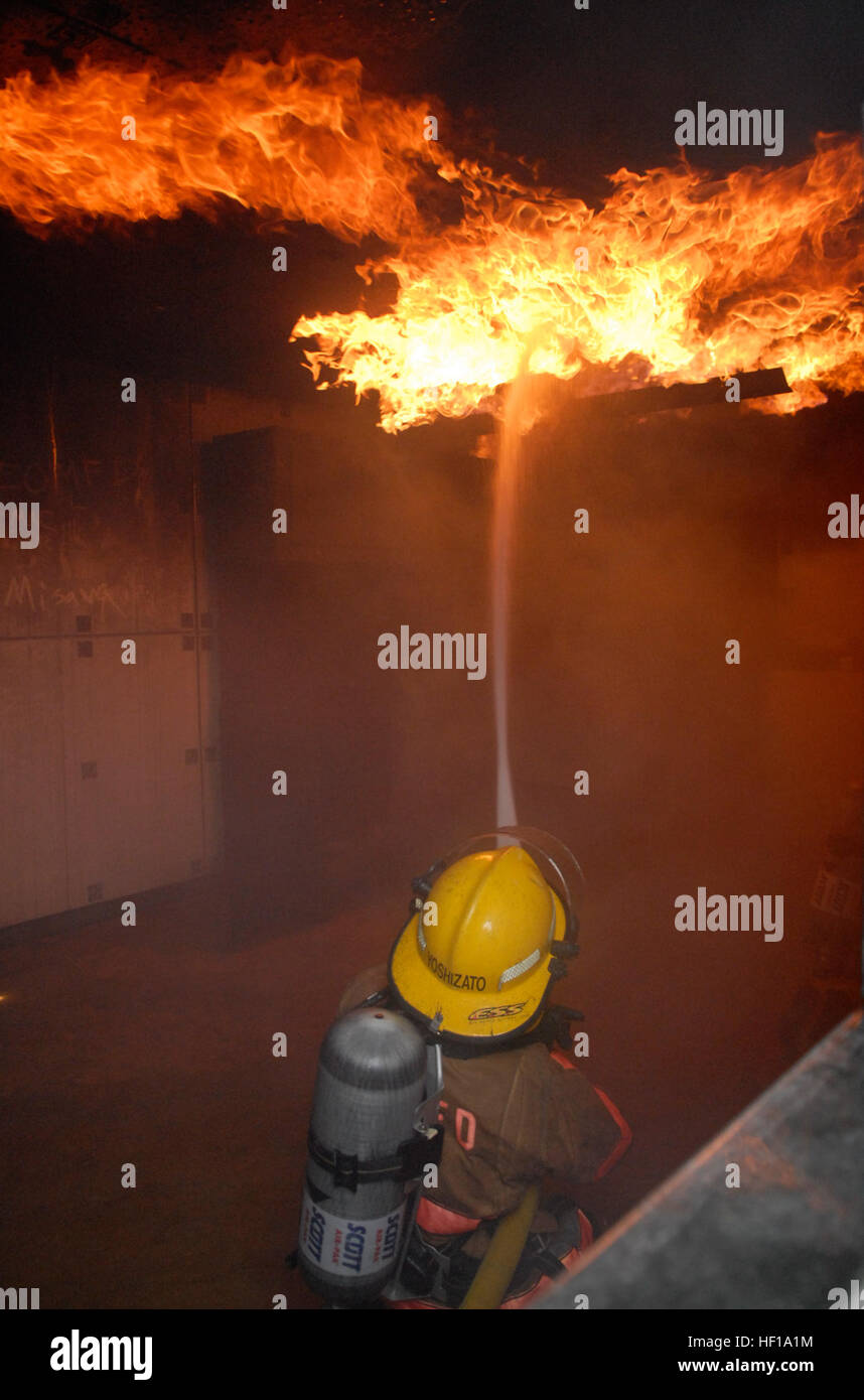 A firefighter with Marine Corps Bases Japan Fire Department battles a ...