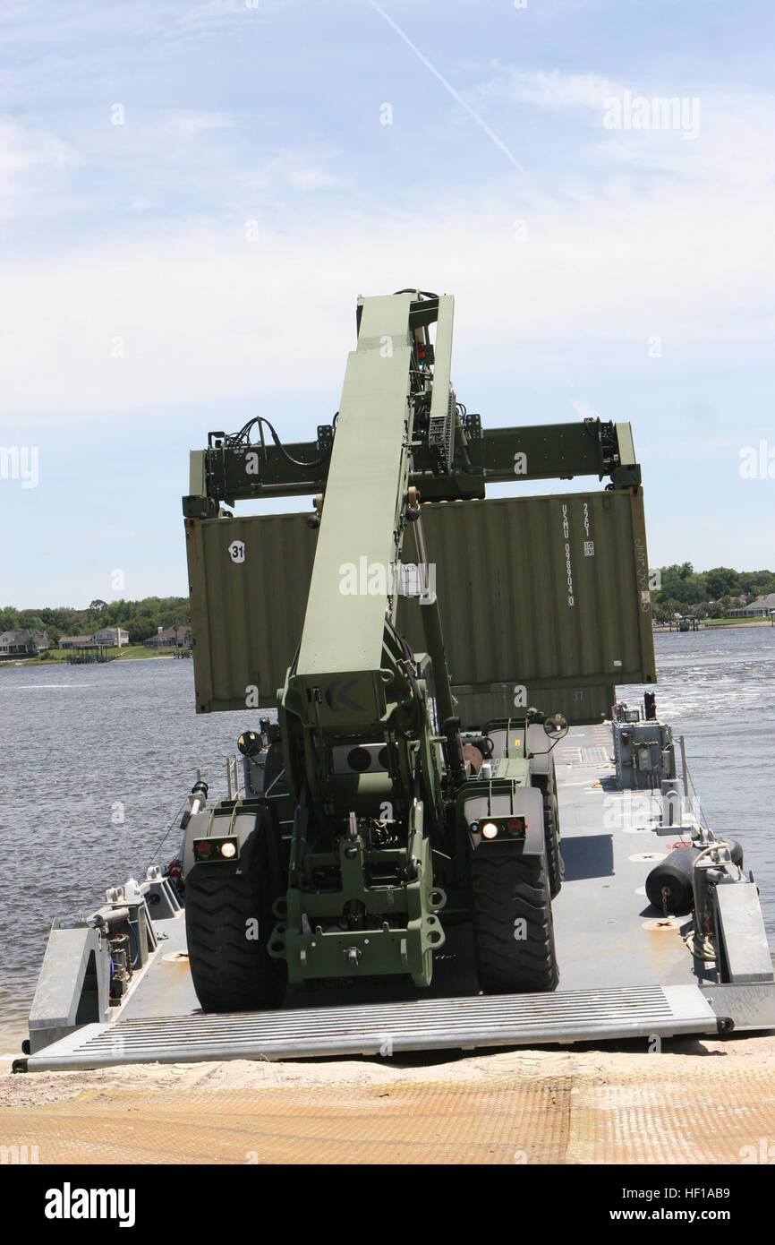 A Kalmar unloads an intermodal container from a Navy lighterage vessel ...