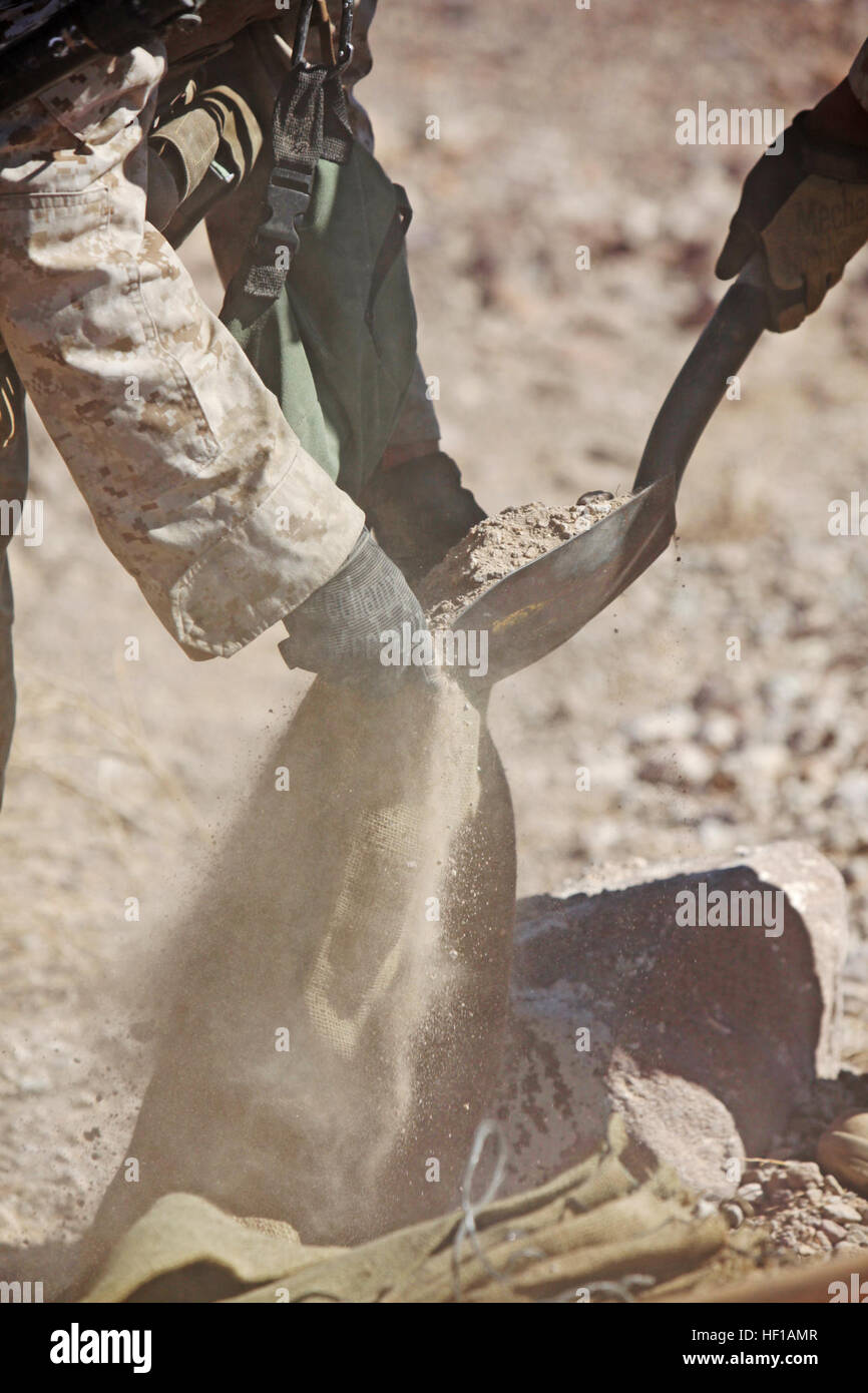 Marines fill a sand bag while setting up a security parameter at ...