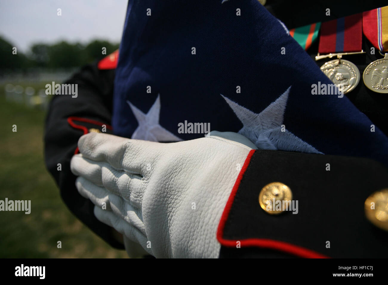 A folded national ensign is held carefully prior to the burial of Maj ...