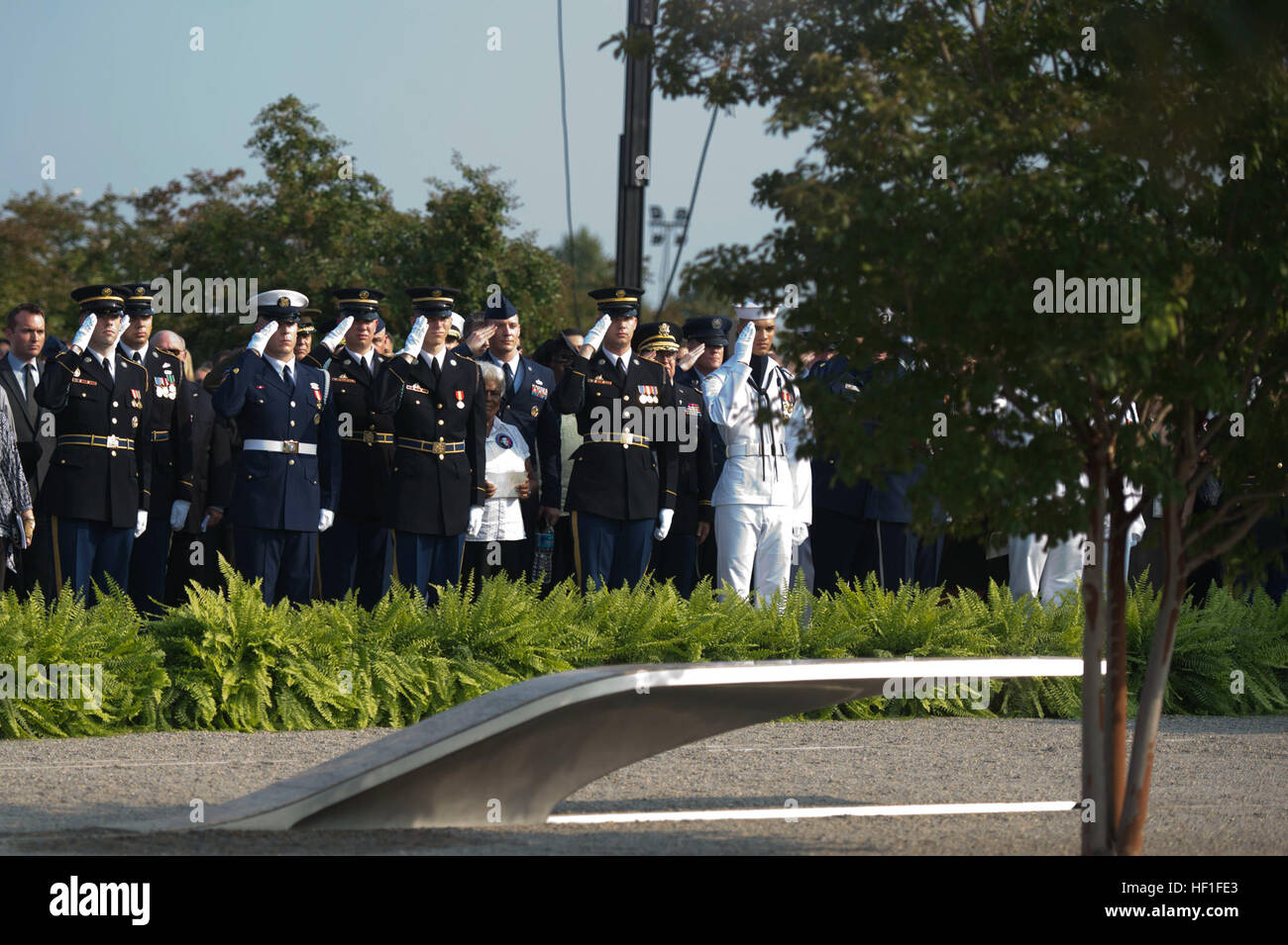 U.S. service members salute as President Barack Obama lays a wreath ...