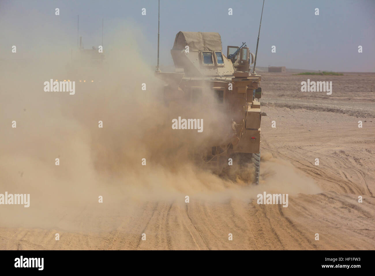 A Mine Resistant, Ambush Protected vehicle kicks up a wall of sand ...