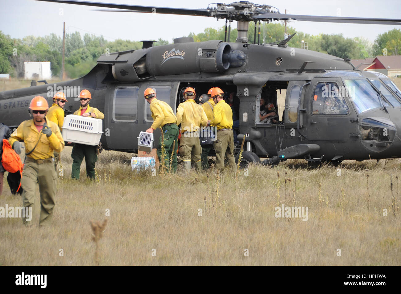 Civilian rescue personnel assisted flood evacuees arriving by UH-60 ...