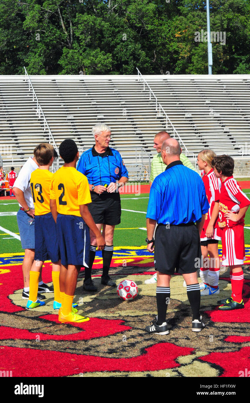 Referees, coaches and team captains meet before a middle school soccer ...
