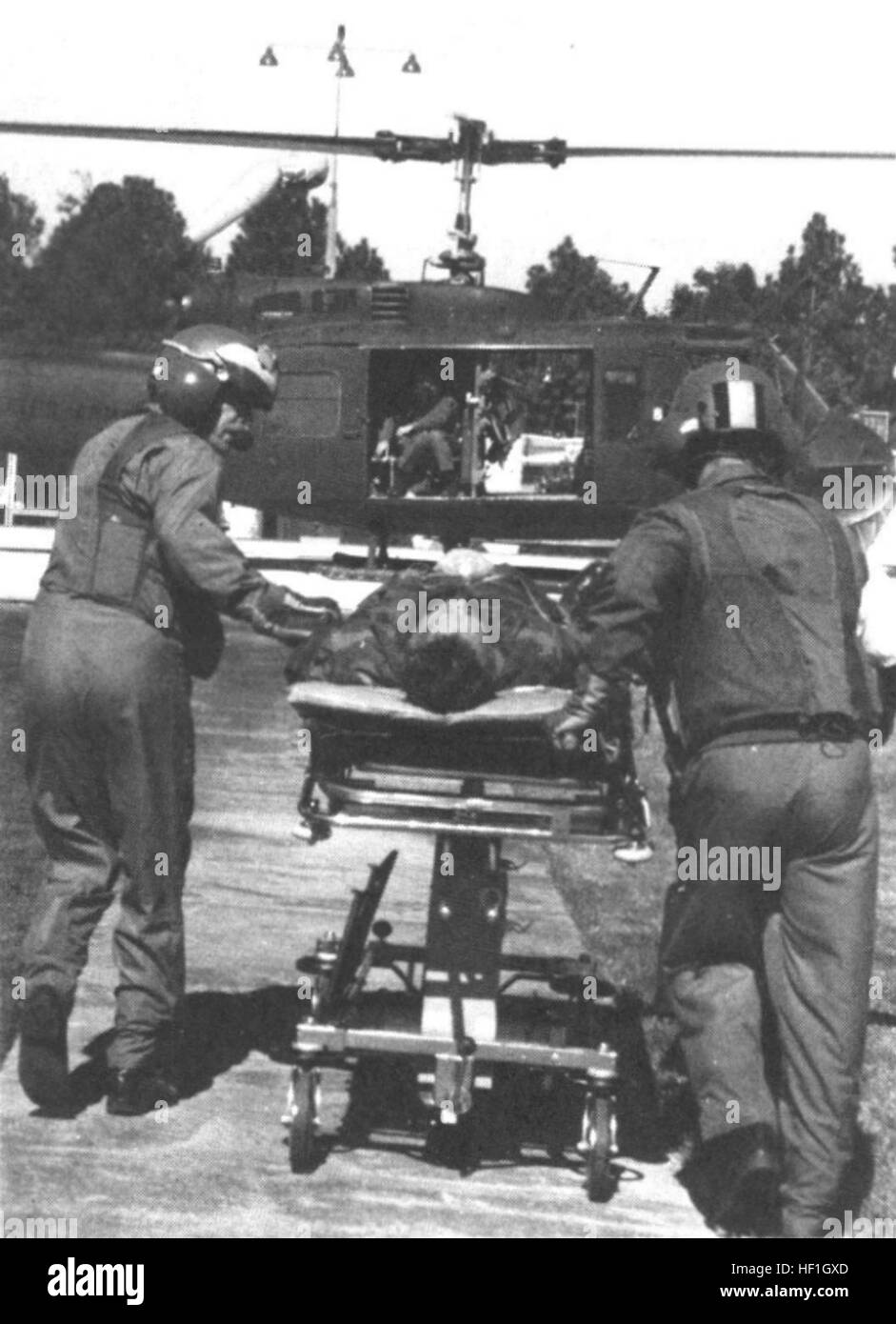 A crew chief and paramedic transport an injured soldier to a MEDEVAC ...