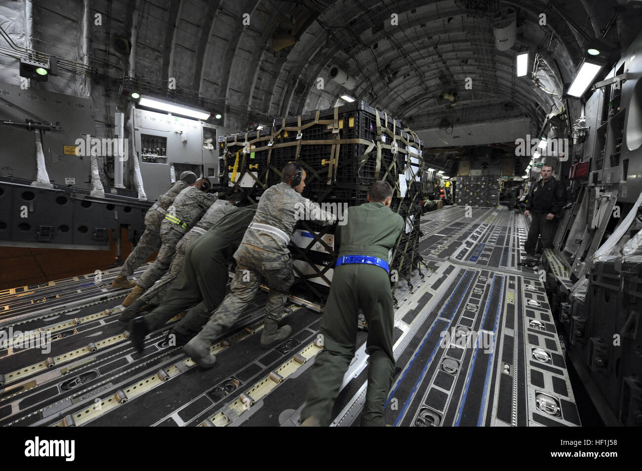 U.S. Air Force members load a pallet onto a U.S. Air Force C-17A Globe ...