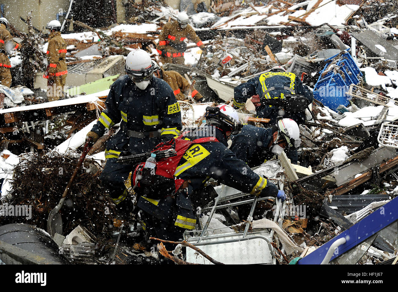 Members with the Japanese Search and Rescue team search through the ...