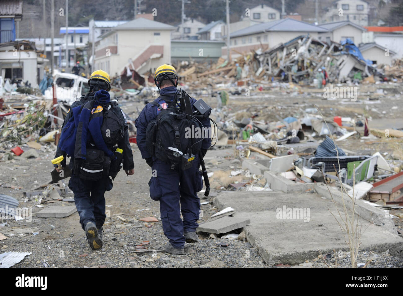 Members of CA-TF2 walk through the rubble to their bus after searching for tsunami victims in ...