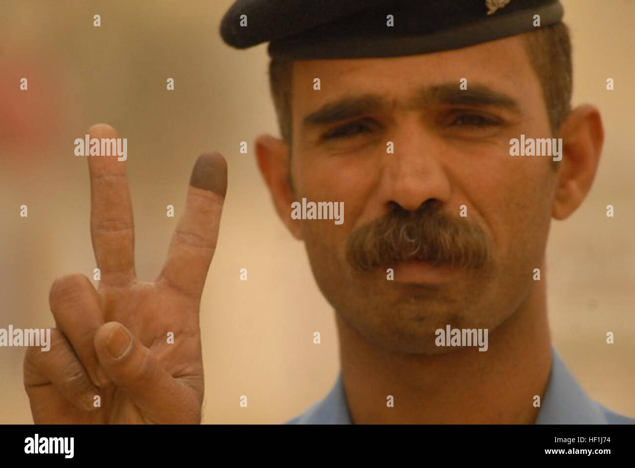 An Iraqi policeman proudly displays his ink-stained finger on the ...