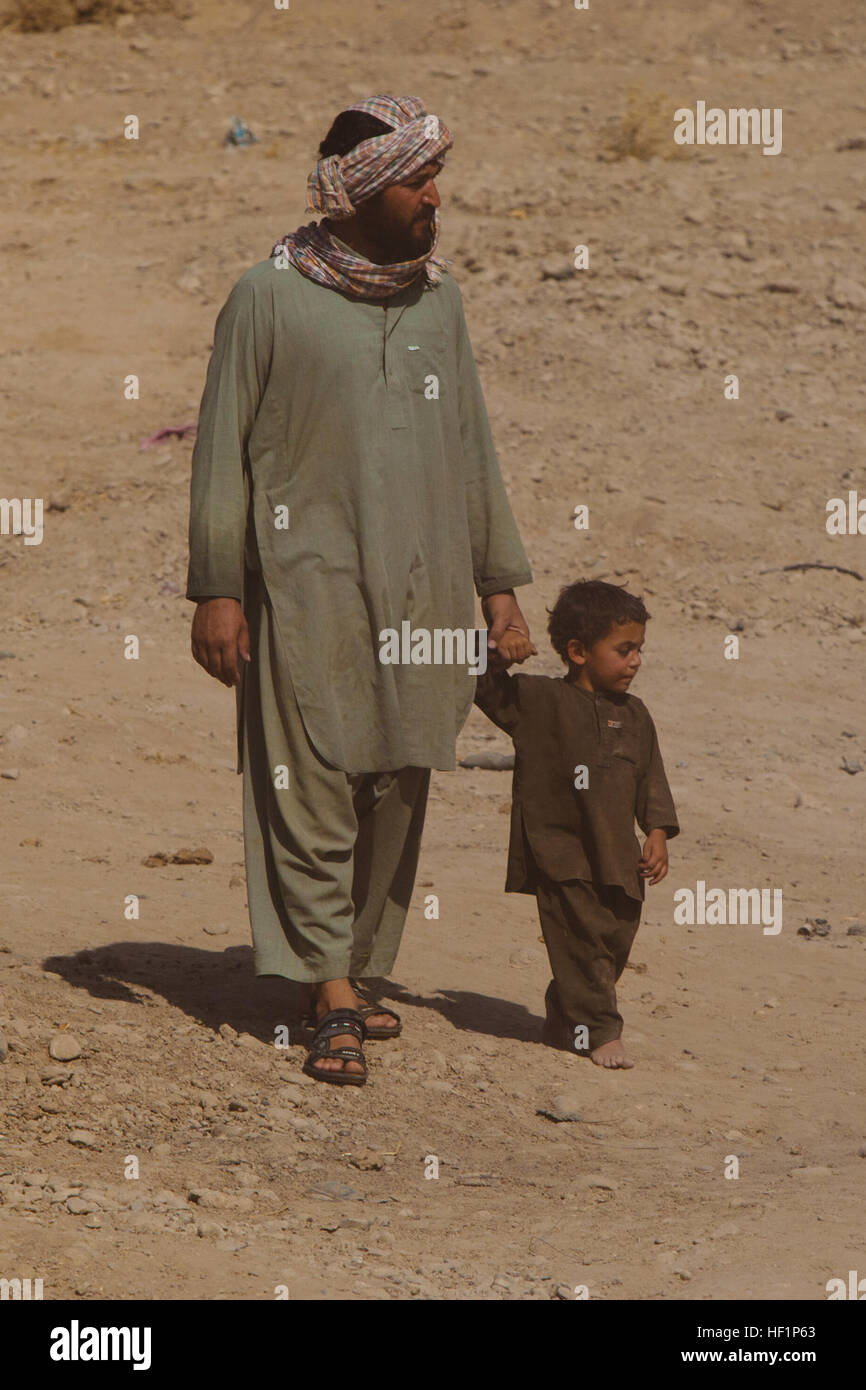 Local Afghans watch a convoy of Marines with Combat Logistics Regiment ...