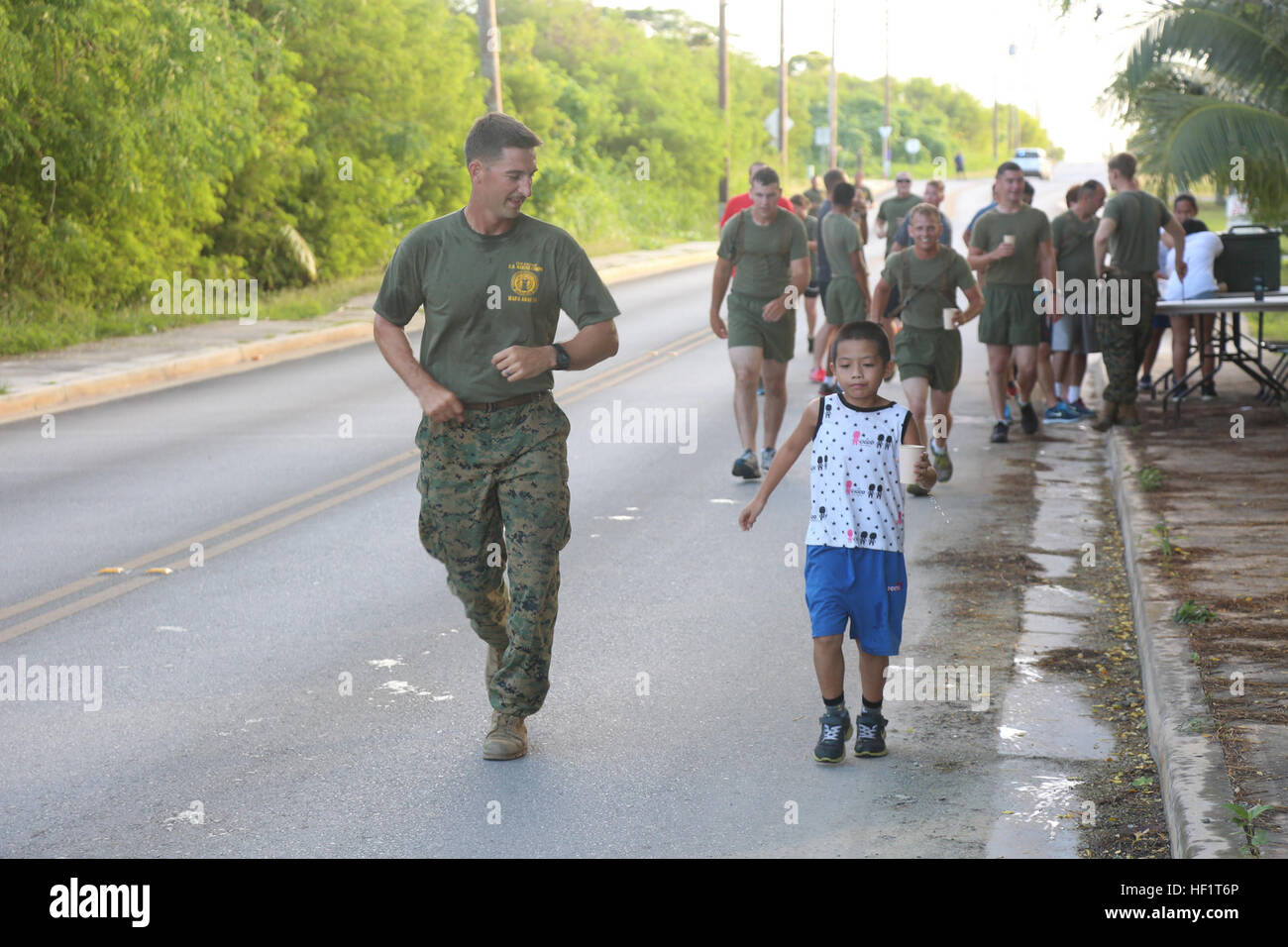 1st Lt. Alex Cloninger runs alongside Harry Fang, 8, who finished the ...