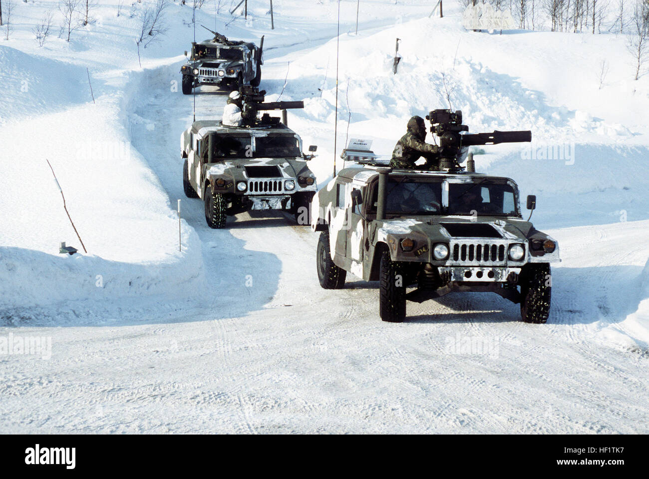 A convoy of M-998 series multipurpose-wheeled vehicles proceeds through ...