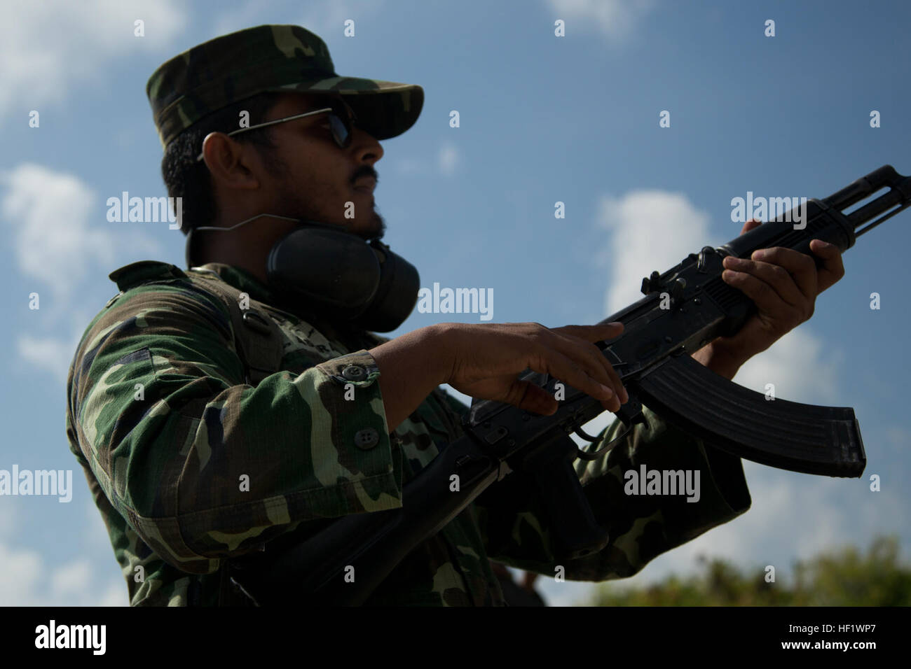 A Maldives National Defense Force (MNDF) service member reloads his ...