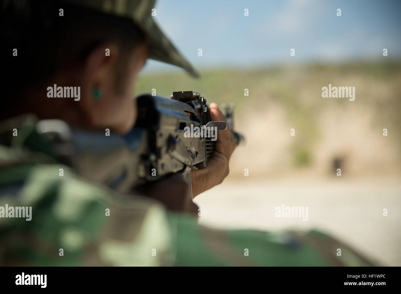 A Maldives National Defense Force (MNDF) service member fires a rifle ...