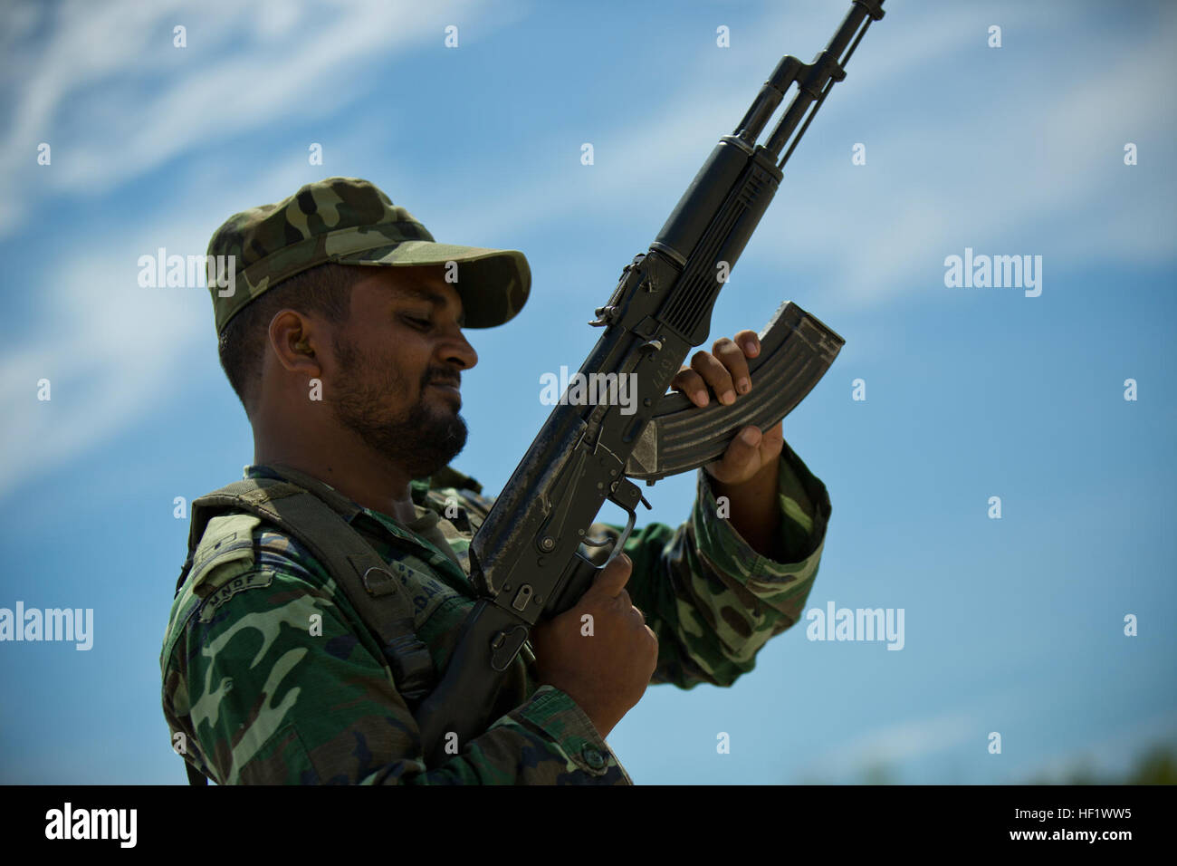 A Maldives National Defense Force (MNDF) service member loads his rifle ...