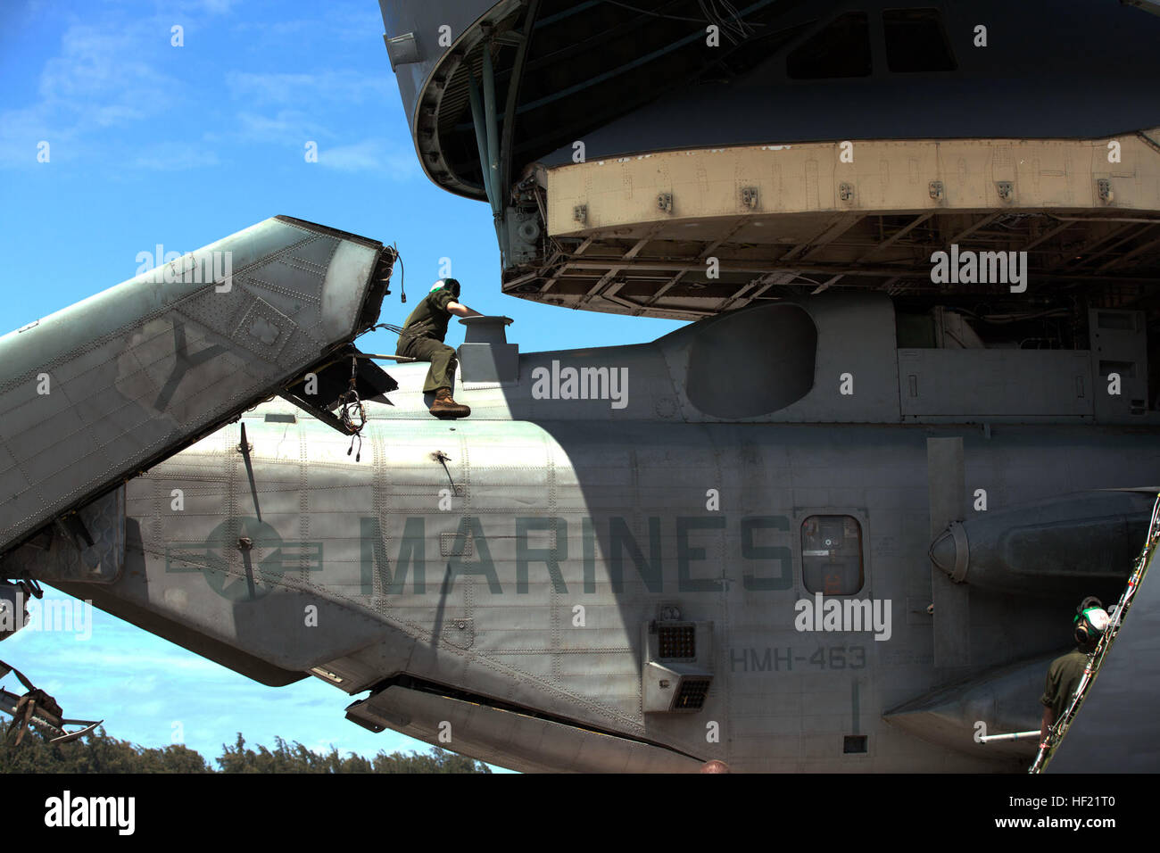 A Marine with Marine Heavy Helicopter Squadron 463 sits on top of a CH ...