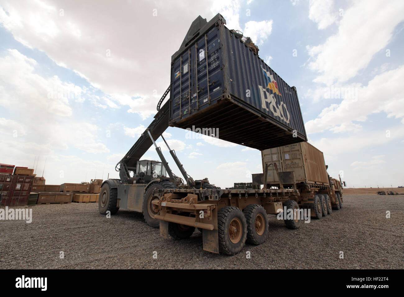 A Rough Terrain Container Handler loads a supply container onto a ...