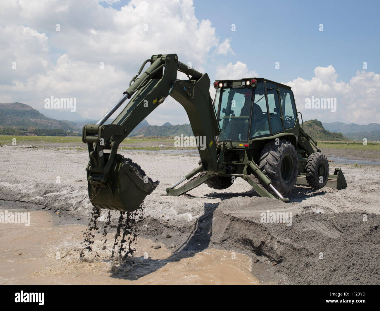Sgt. Andre T. Diaz operates a backhoe to dig a pond so the unstable ...
